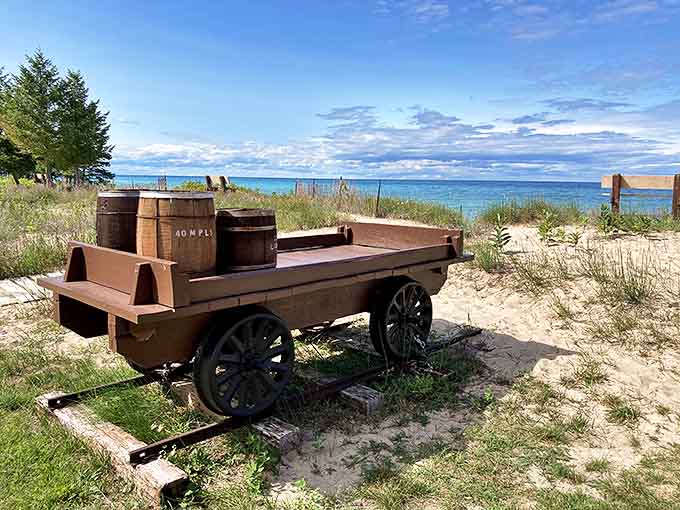 An authentic supply wagon stands ready on the sandy shore, representing the lifeline of deliveries that sustained lighthouse keepers through Michigan's harshest seasons.