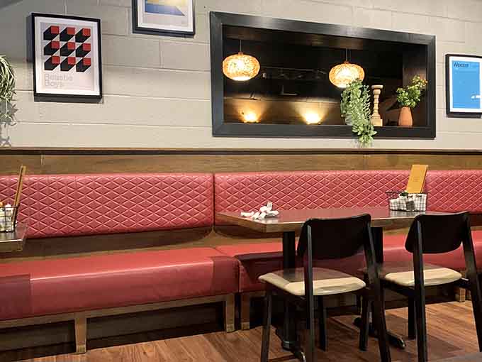 Coral banquette seating and thoughtful design details create an upscale-casual vibe that feels both contemporary and comfortable throughout the space.