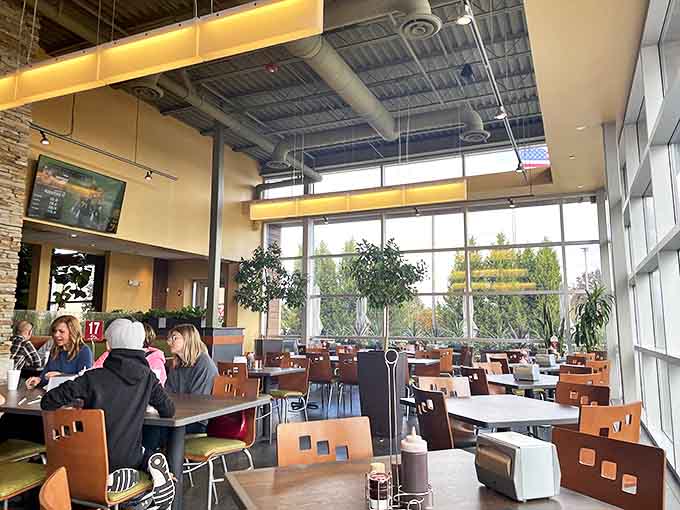 Floor-to-ceiling windows flood the dining area with natural light, creating a bright, airy atmosphere that enhances the dining experience.