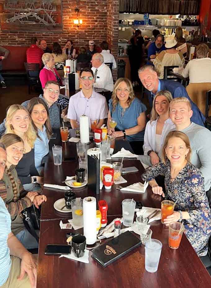 Happy diners gather around tables filled with food and drinks, creating the kind of scene Norman Rockwell would've painted if he'd loved sports bars.