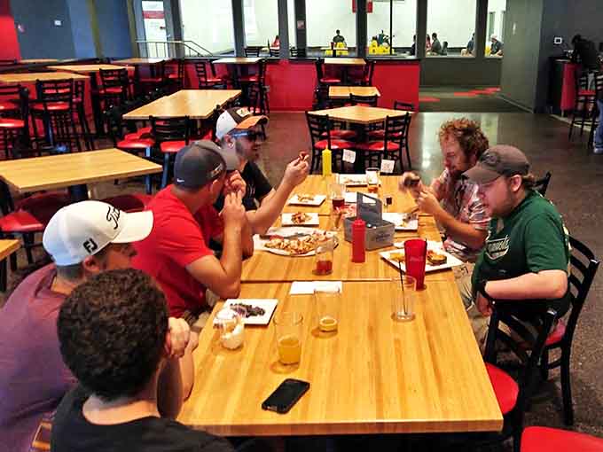 Friends gather around tables laden with surprisingly delicious food, swapping exaggerated stories of their gaming prowess between bites of perfectly crispy appetizers.