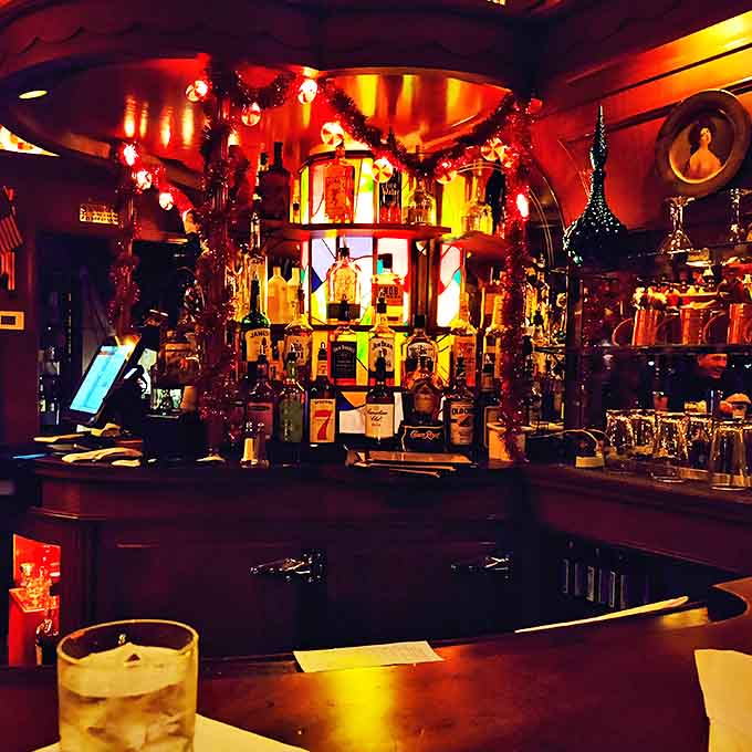 Bottles gleam like liquid jewels behind the bar, promising classic cocktails made by hands that understand proper proportions matter.