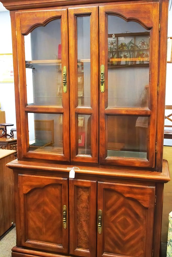 This elegant wooden china cabinet once proudly displayed someone's finest dinnerware; now it awaits its next chapter in a new home.