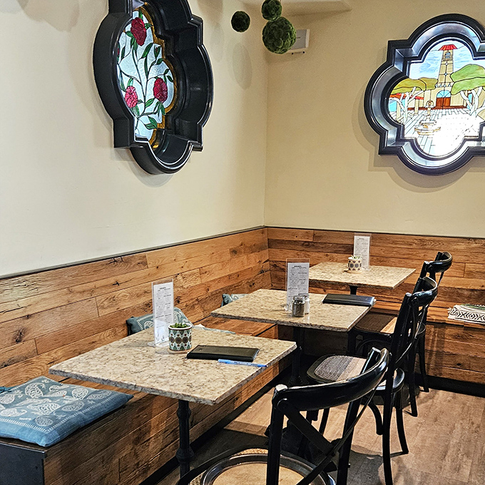 Stained glass accents and wooden wainscoting transform a simple dining nook into a cozy retreat that feels worlds away from ordinary caf&eacute; experiences.