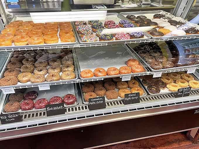 The meticulously arranged display case transforms simple donuts into an art exhibition, with each variety labeled and presented with pride.