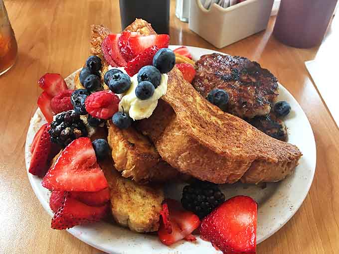 French toast elevated to art form &ndash; golden slices adorned with fresh berries and a dusting of powdered sugar that would make any breakfast table Instagram-worthy.