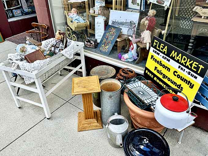 Various collectibles spill onto the sidewalk like an invitation, the yellow flea market sign announcing weekend adventures for treasure hunters.