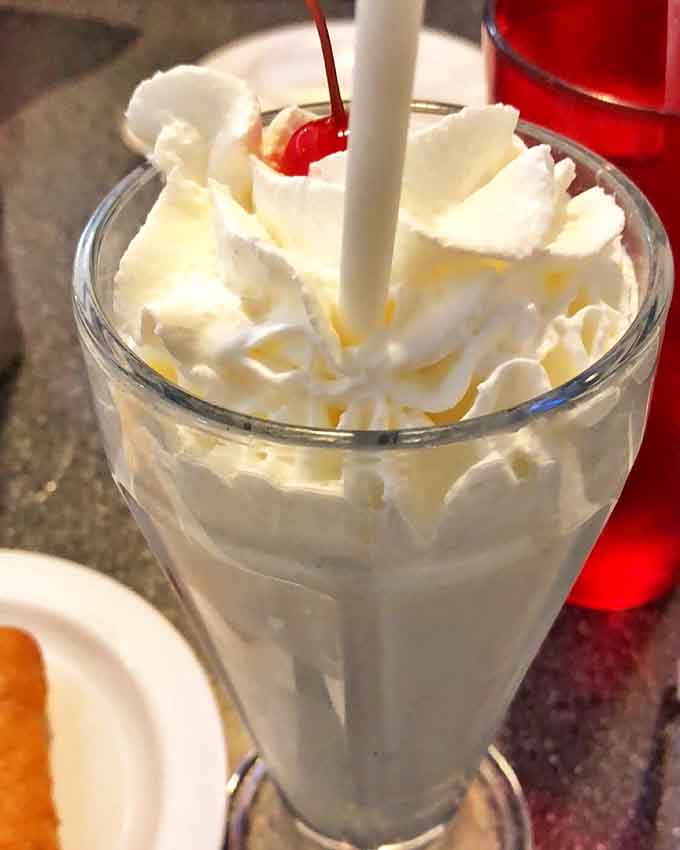 This milkshake is so thick it practically requires a spoon, topped with enough whipped cream to make your dentist nervous.