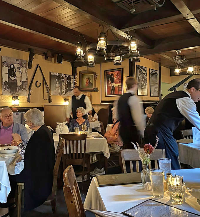 Tables draped in crisp white linens await beneath rustic wooden beams, creating that perfect balance of elegance and comfort that defines the best dining experiences.