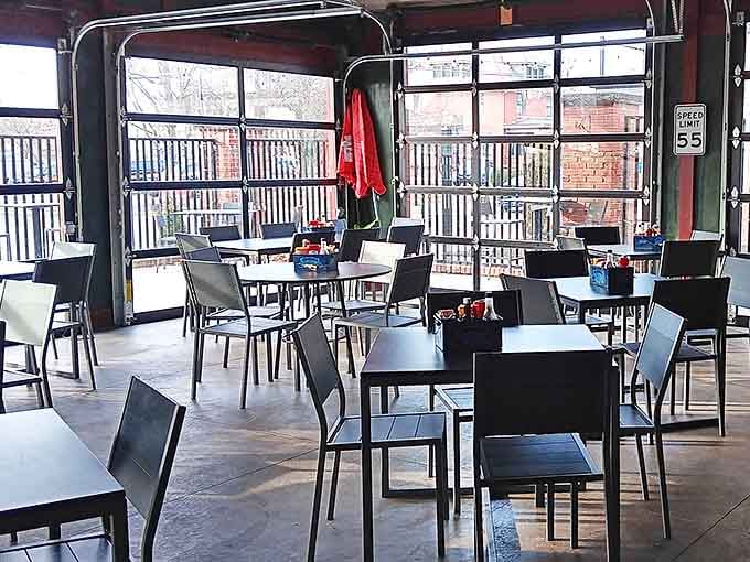 The modern outdoor seating area offers a contemporary contrast to the historic interior, with garage doors that open completely during pleasant weather.