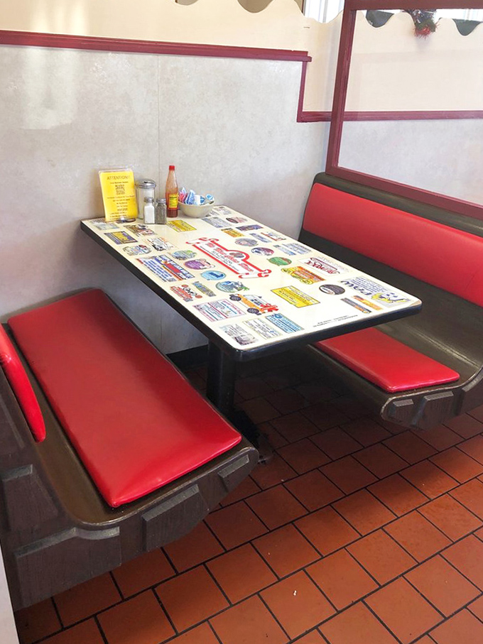 The classic diner booth experience &ndash; laminated tabletop, red vinyl seating, and the promise of comfort food just moments away.
