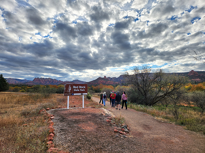 The Red Rock State Park entrance welcomes hikers beneath dramatic skies, promising adventures worthy of the journey.