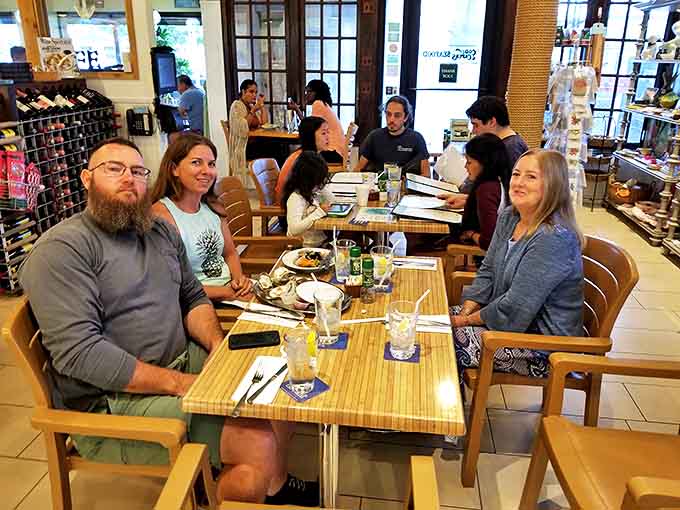 Happy diners sharing stories and seafood &ndash; the unofficial Cod & Capers club where friendships form over stone crabs and shared recommendations.