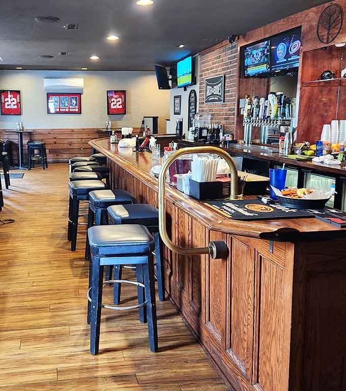 The curved bar invites conversation and cold beverages, with plenty of taps offering refreshing options for every preference.