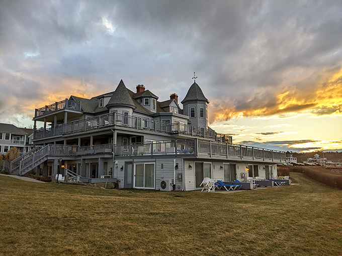 Turrets and balconies silhouetted against a fiery Maine sunset, where Victorian grandeur meets modern luxury.