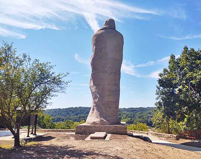 From behind, the statue's massive form creates an imposing silhouette against the bright blue Illinois sky.