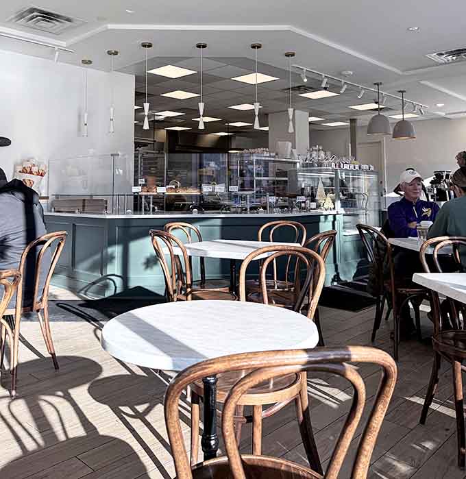 Bentwood chairs and natural light create an inviting space where lingering over coffee and pastries feels absolutely right.