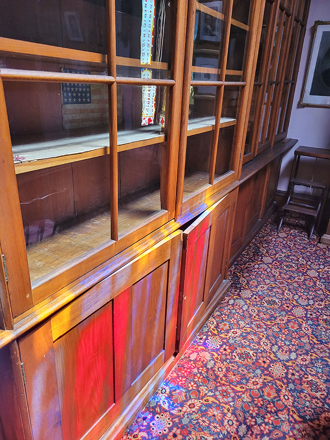 Custom cabinetry with colorful panels showcases 19th-century craftsmanship and attention to detail.