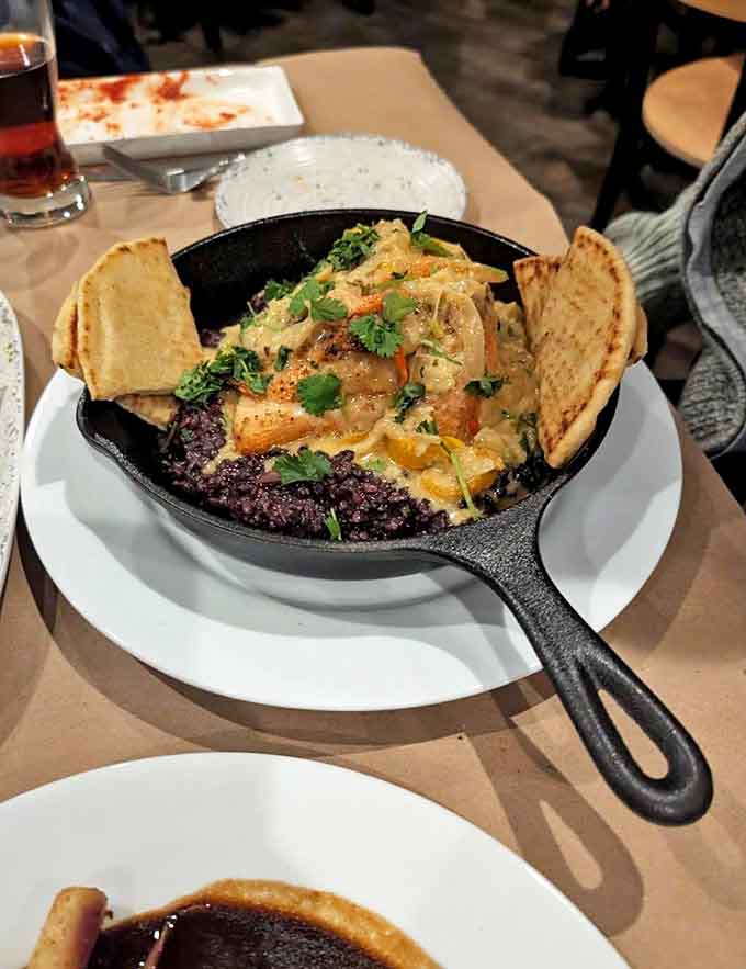 This cast-iron skillet arrives sizzling with layers of flavor, from the black beans to the melted cheese, demanding your immediate attention and appetite.