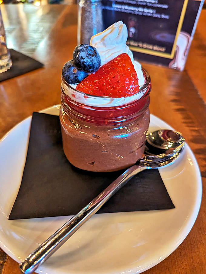 A mason jar of velvety chocolate decadence topped with fresh berries – proof that sometimes the best things come in small, unpretentious packages.