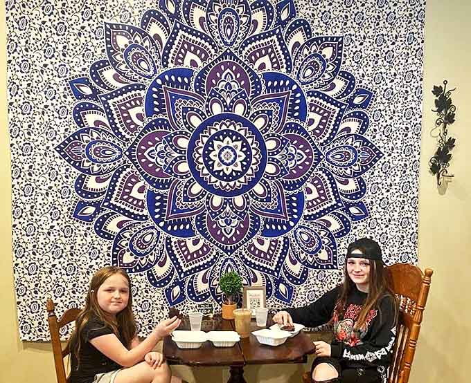 Young visitors enjoy treats at a wooden table, surrounded by bohemian decor that creates a welcoming atmosphere for all ages.