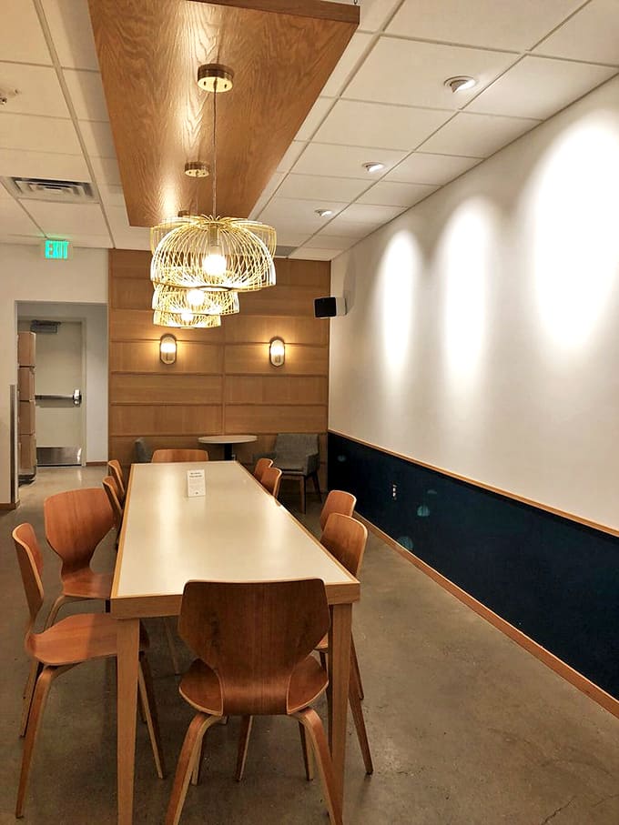 The dining room's thoughtful design, with its golden pendant lights and warm wood tones, elevates the humble donut shop to something special.