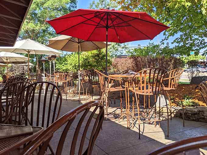 Colorful umbrellas dot the patio like cheerful mushrooms, providing shade and style for those who prefer their meals with fresh air.