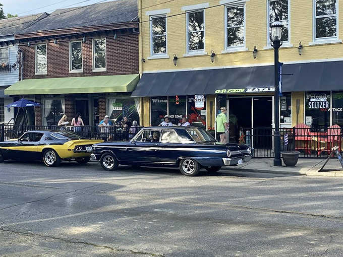 Classic cars parked outside Green Kayak Grille & Pub create a scene that blends nostalgia with the promise of cold craft beers and riverside views.