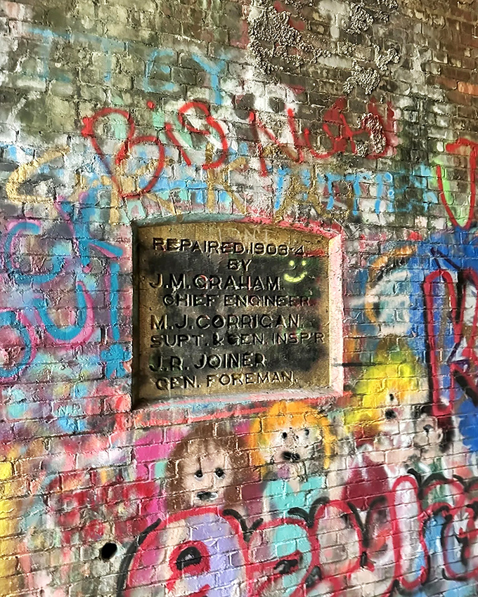 A historic plaque reveals the tunnel's 1906 repair details, a small but significant chapter in its continuing story.