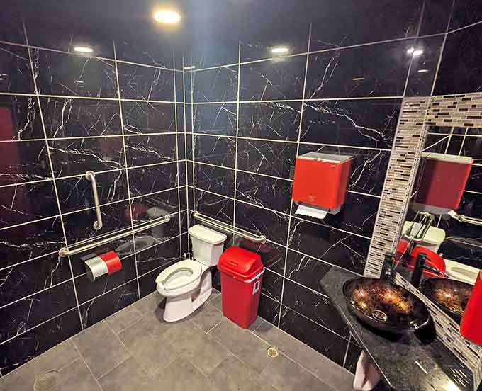 Even the restroom gets attention to detail, with bold black marble-look tiles and pops of red showing care throughout.