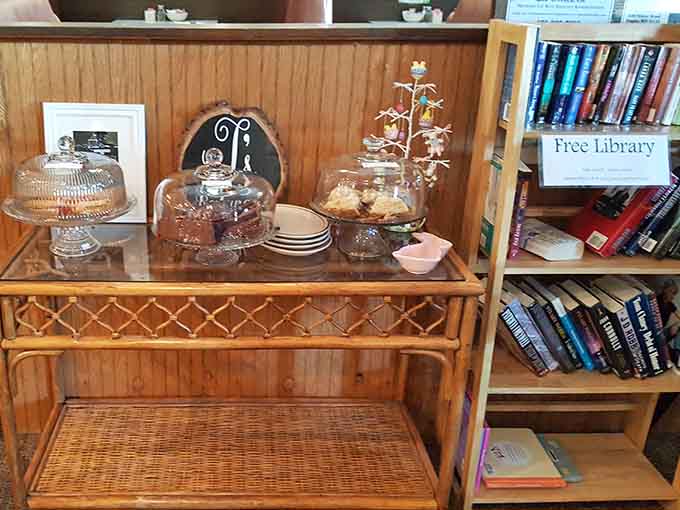 A free library sits next to the dessert display because J's believes in feeding both your stomach and your mind, though the cakes might prove more tempting than the books.