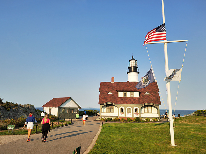 The American flag stands proud beside the lighthouse, two enduring symbols of guidance and hope on Maine's picturesque coastline.