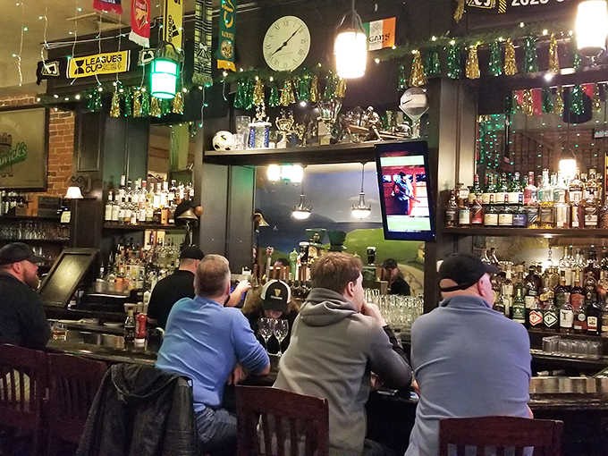 The bar comes alive with patrons leaning in for conversation, creating that magical pub energy where strangers become friends over shared stories and pints.