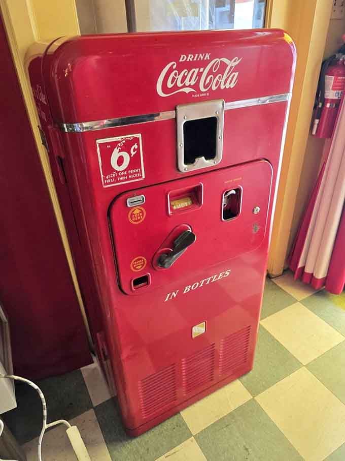 A vintage Coke machine that dispensed happiness for six cents, back when inflation was something that only happened to balloons.