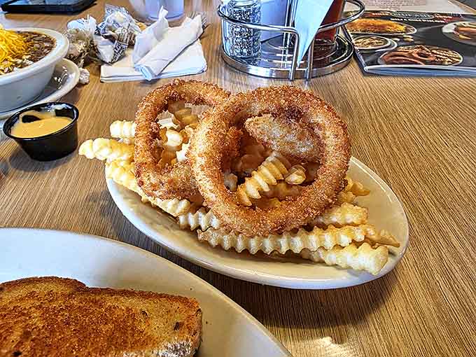 These aren't just any onion rings &ndash; they're crispy, golden halos of happiness, served with a dipping sauce worth fighting over.