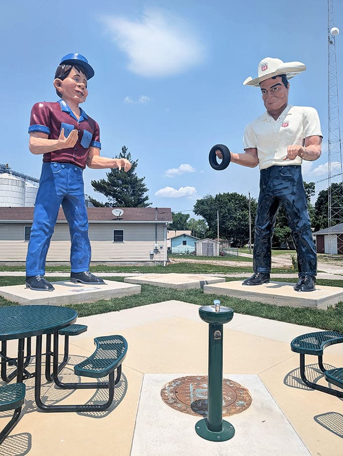 Two giants face off across a drinking fountain, creating a surreal picnic area where visitors can contemplate life among the colossi.