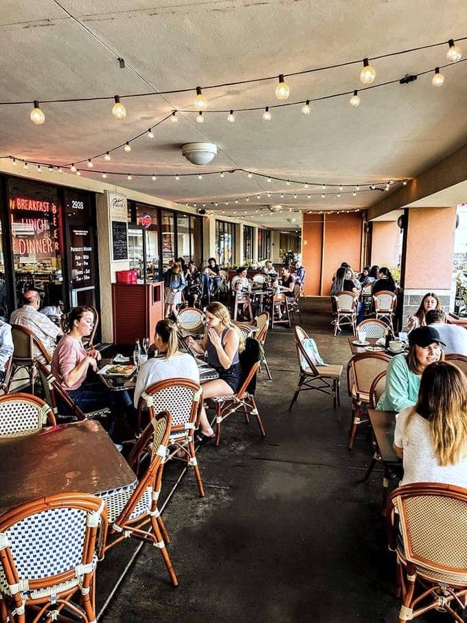 Outdoor seating strung with lights transforms a Minnesota shopping center into a Parisian sidewalk cafe, minus the cigarette smoke thankfully.