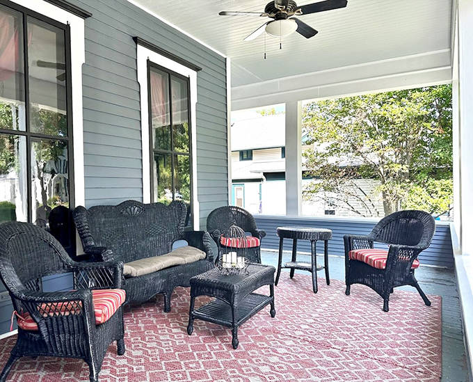 Wicker furniture and brick flooring create an outdoor living room where conversations flow as easily as the evening wine – Victorian socializing at its finest.