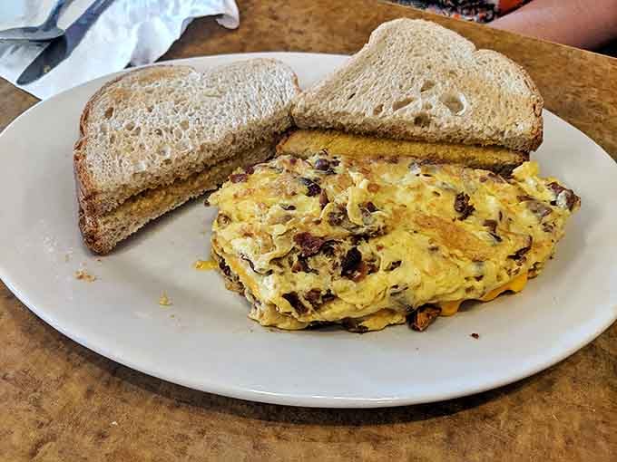 Breakfast simplicity executed perfectly &ndash; a cheese-filled omelet with savory sausage bits and buttery rye toast.