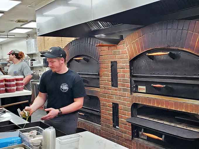 Behind those brick ovens, skilled hands transform dough and toppings into the pizzas that keep people coming back for more.