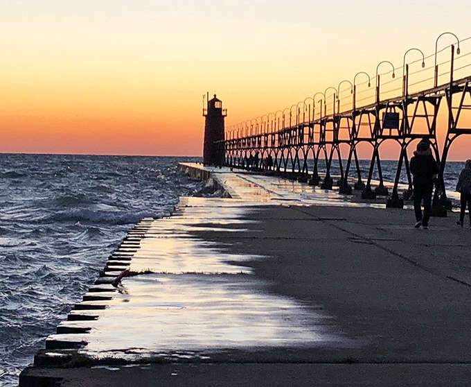South Haven's pier at sunset transforms into a silhouetted catwalk against nature's most spectacular light show.