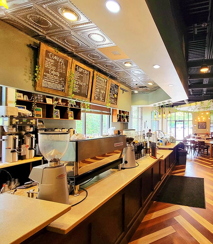 Another angle of the counter shows the full operation, from coffee equipment to pastry displays to the humans making it all work.