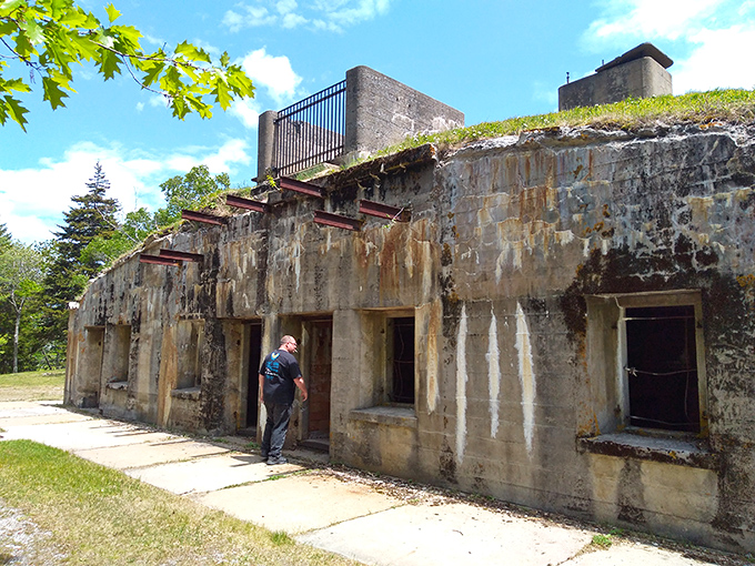 A visitor examines Fort Baldwin's weathered walls, where a century of Maine winters has etched character into what was once cutting-edge military technology.