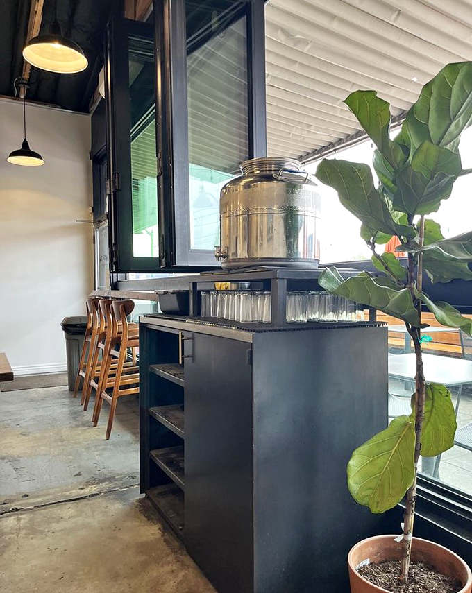 Even hydration gets the Worth treatment &ndash; a gleaming metal dispenser stands ready beside wooden stools and lush greenery.