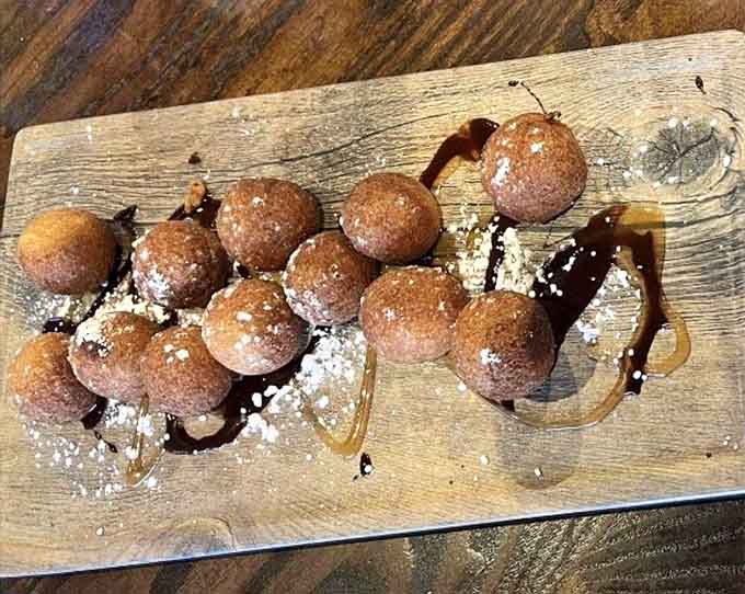 Fried donut holes dusted with powdered sugar provide the sweet ending your meal deserves.