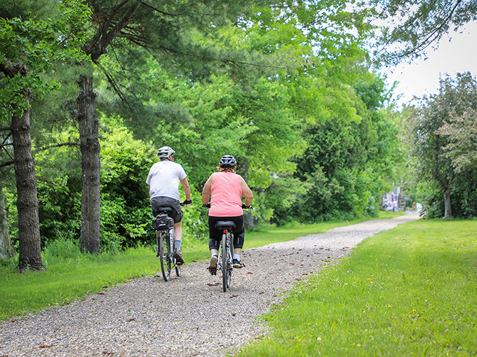 Two cyclists explore the gentle curves of Poultney's rail trail, proving that the best way to see Vermont is at the pace of a leisurely pedal.