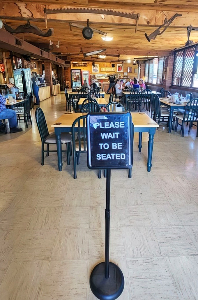"Please Wait to Be Seated" &ndash; the dining area combines rustic charm with practical functionality, where vintage tools and artifacts hang from wooden ceiling beams.