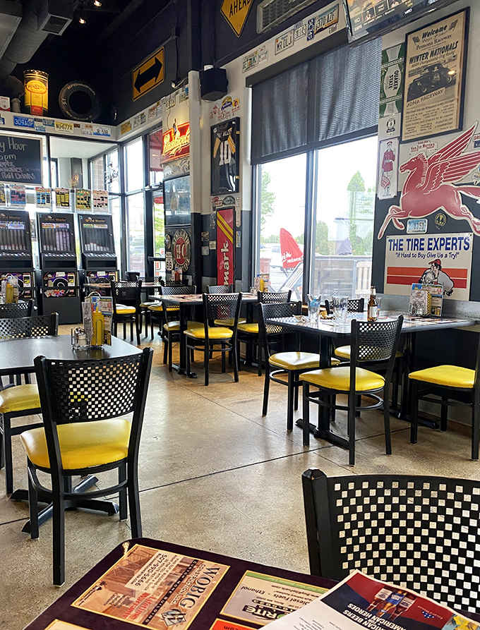 Black walls showcase colorful automotive relics while checkered-back chairs with sunny yellow seats invite you to park yourself for a while.