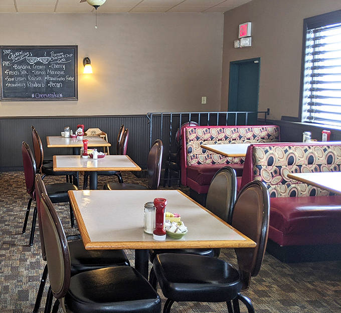 The dining area balances nostalgia with comfort&mdash;simple tables, retro booth upholstery, and a chalkboard announcing the day's pie selections.