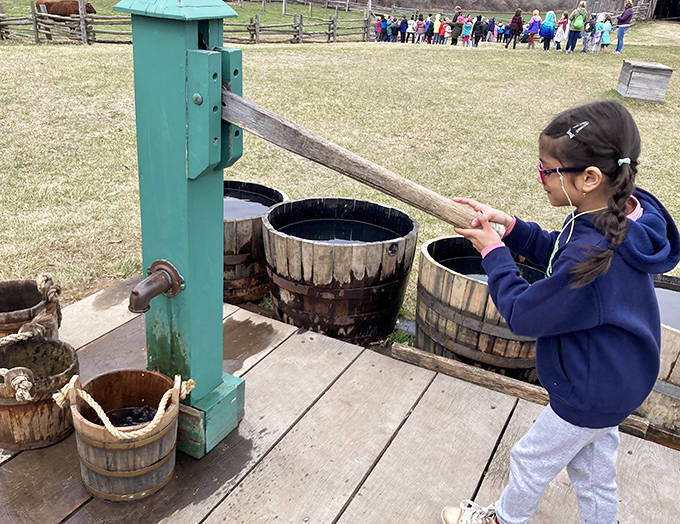 A young visitor discovers the original "app" for getting water &ndash; no electricity required, just good old-fashioned elbow grease.